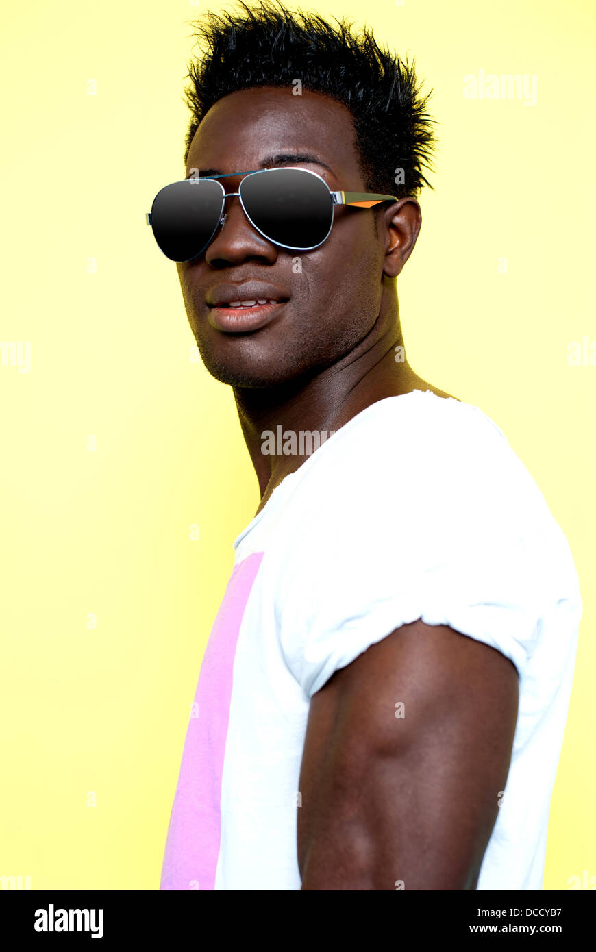 Handsome african guy wearing goggles isolated against yellow background ...