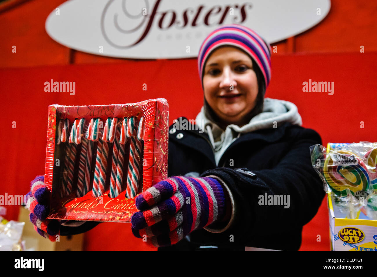A young woman holds up a box of candy canes at a market stall Stock ...