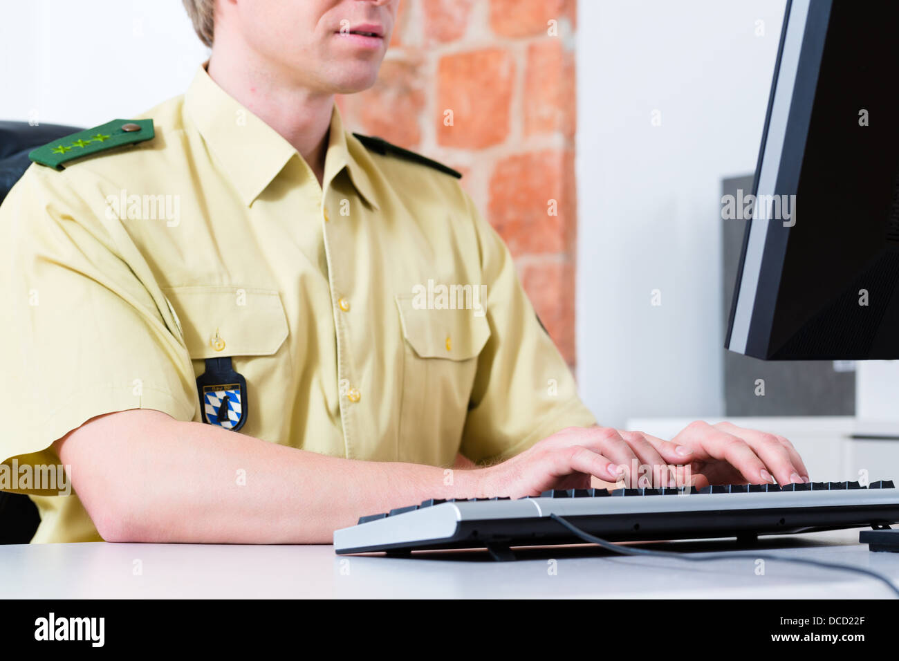 Police officer in police department working on the computer, on a case ...