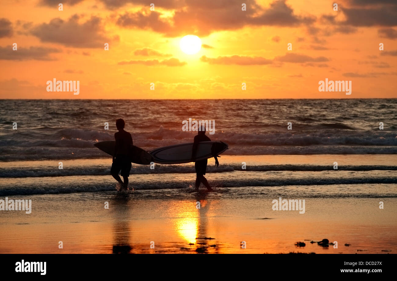 Surfers on sunset Stock Photo - Alamy