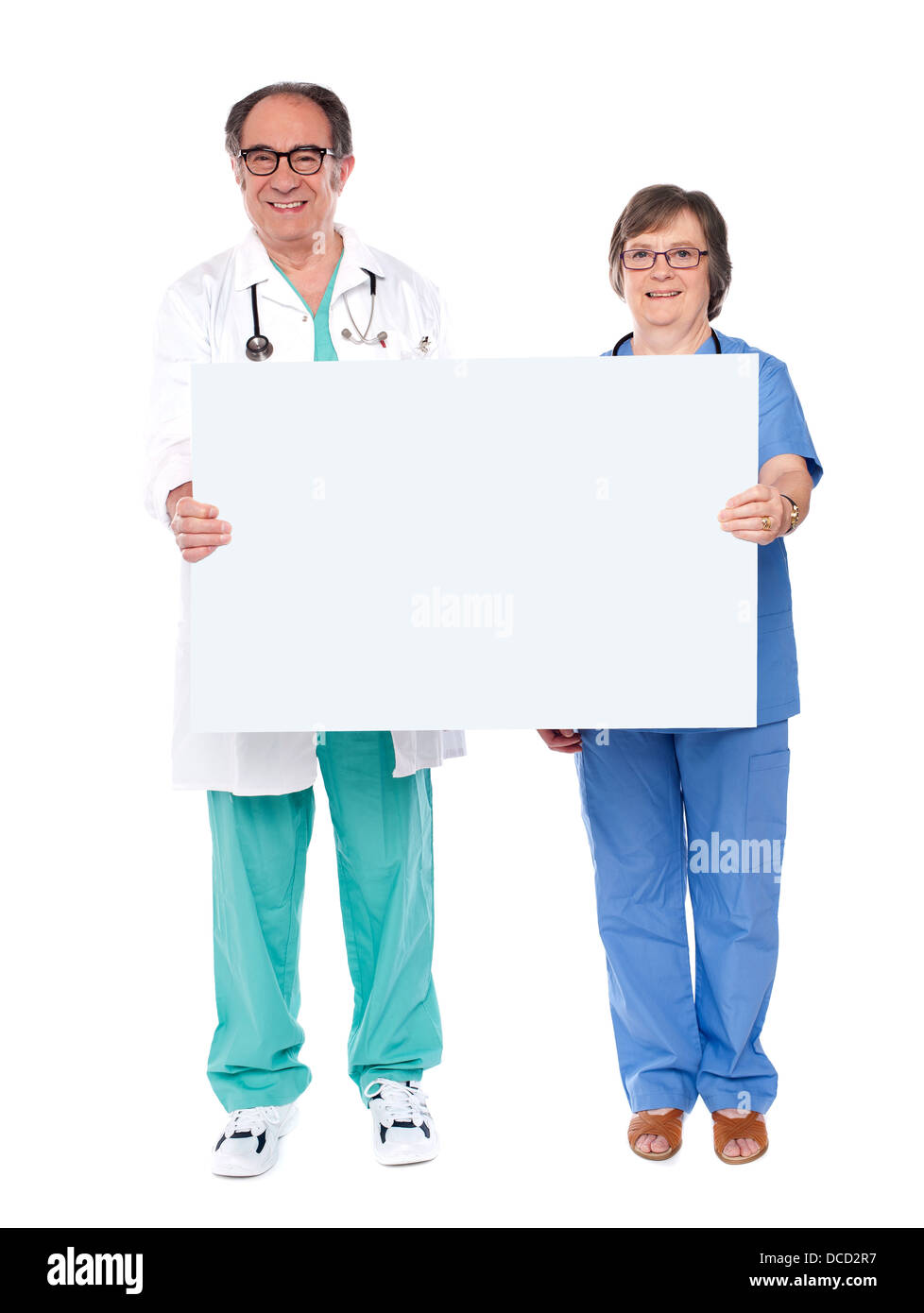 Aged doctors together displaying white billboard. Full length shot ...