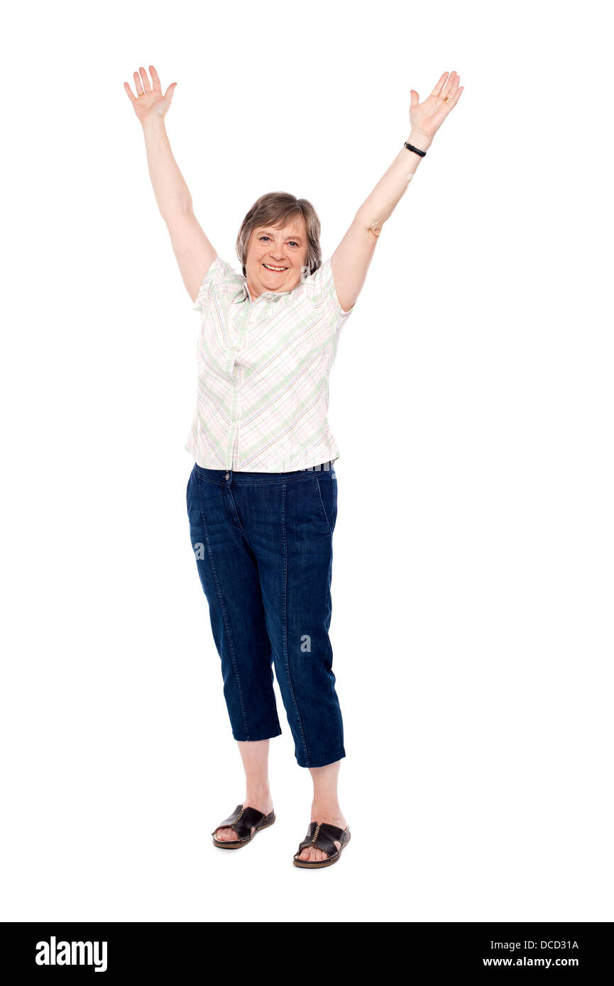 Cheerful senior woman lifting her arms up filled with joy Stock Photo ...