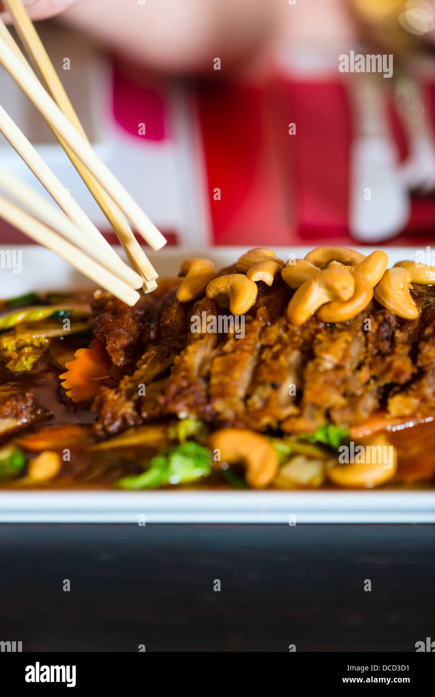 Young people eating in a Thai restaurant, they eating with chopsticks ...