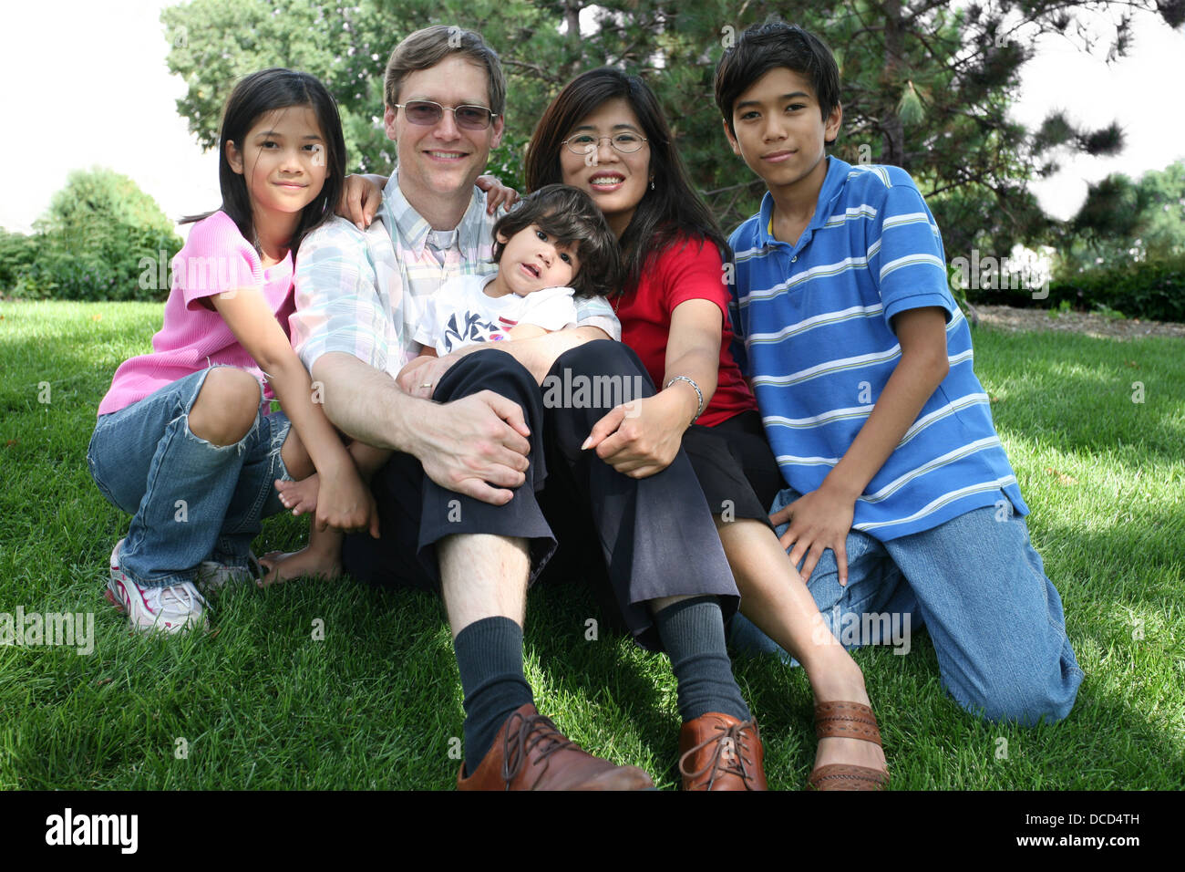 Large multiracial family sitting on lawn Stock Photo - Alamy