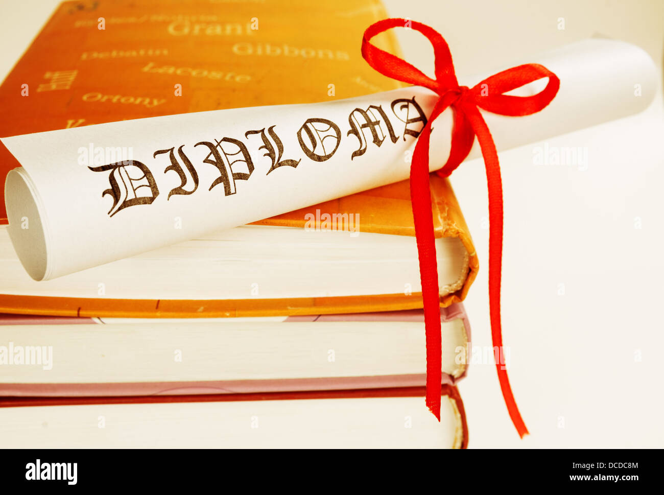 Diploma with red ribbon and books Stock Photo - Alamy