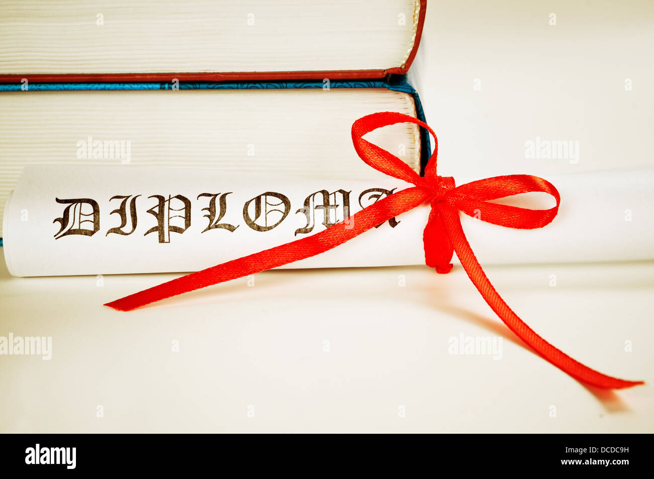 Diploma with red ribbon and books Stock Photo - Alamy
