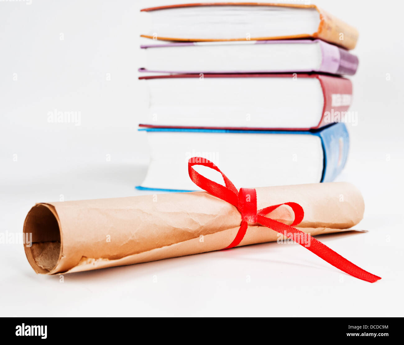 Diploma with red ribbon and books Stock Photo - Alamy