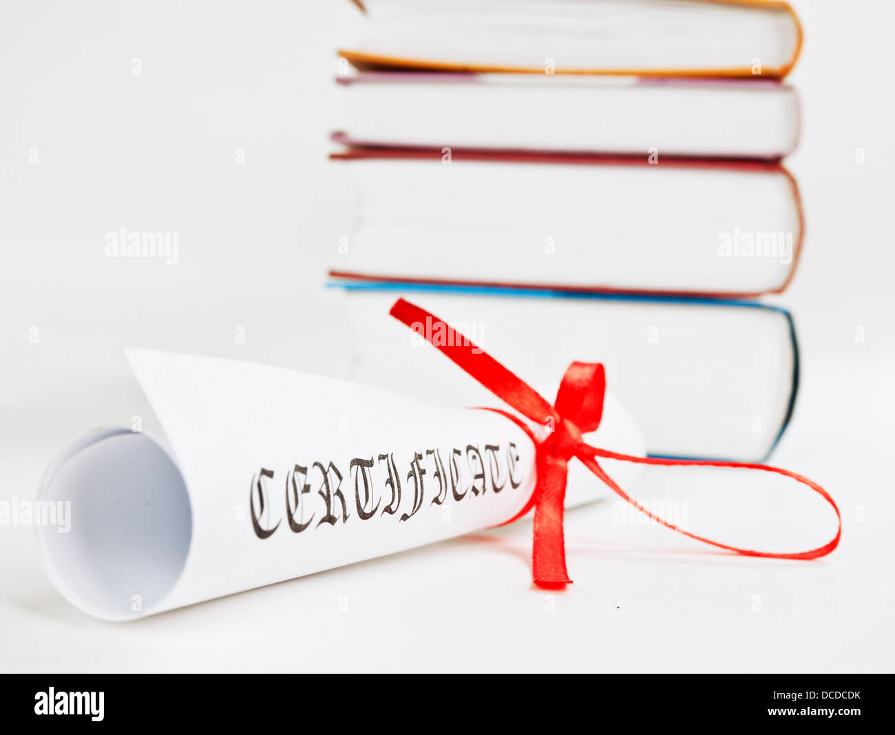 Diploma with red ribbon and books Stock Photo - Alamy