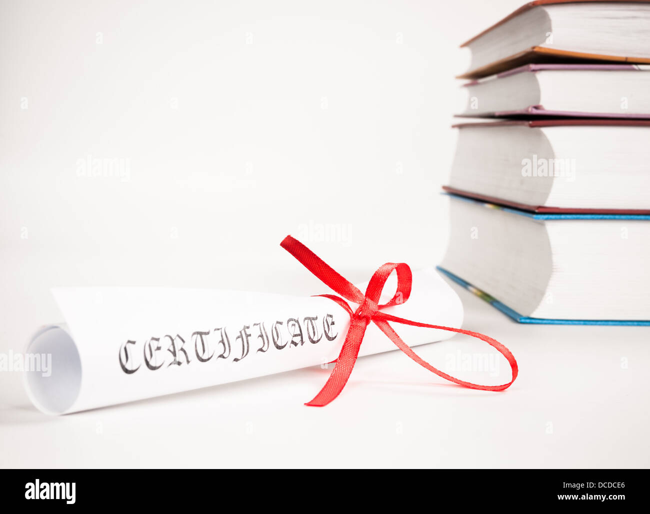 Diploma with red ribbon and books Stock Photo - Alamy