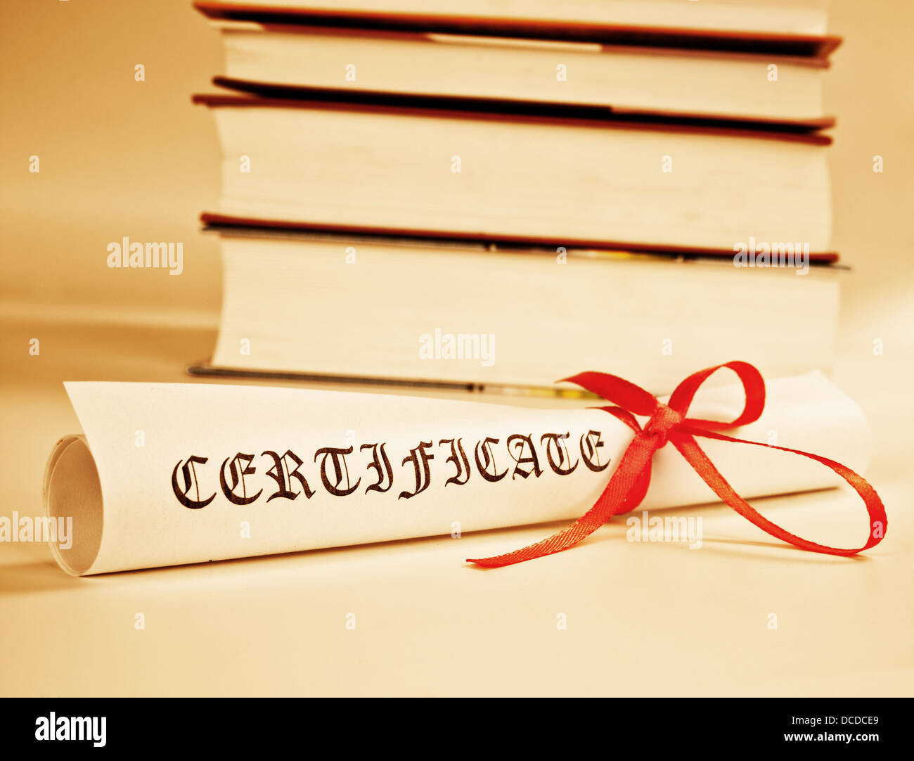 Diploma with red ribbon and books Stock Photo - Alamy
