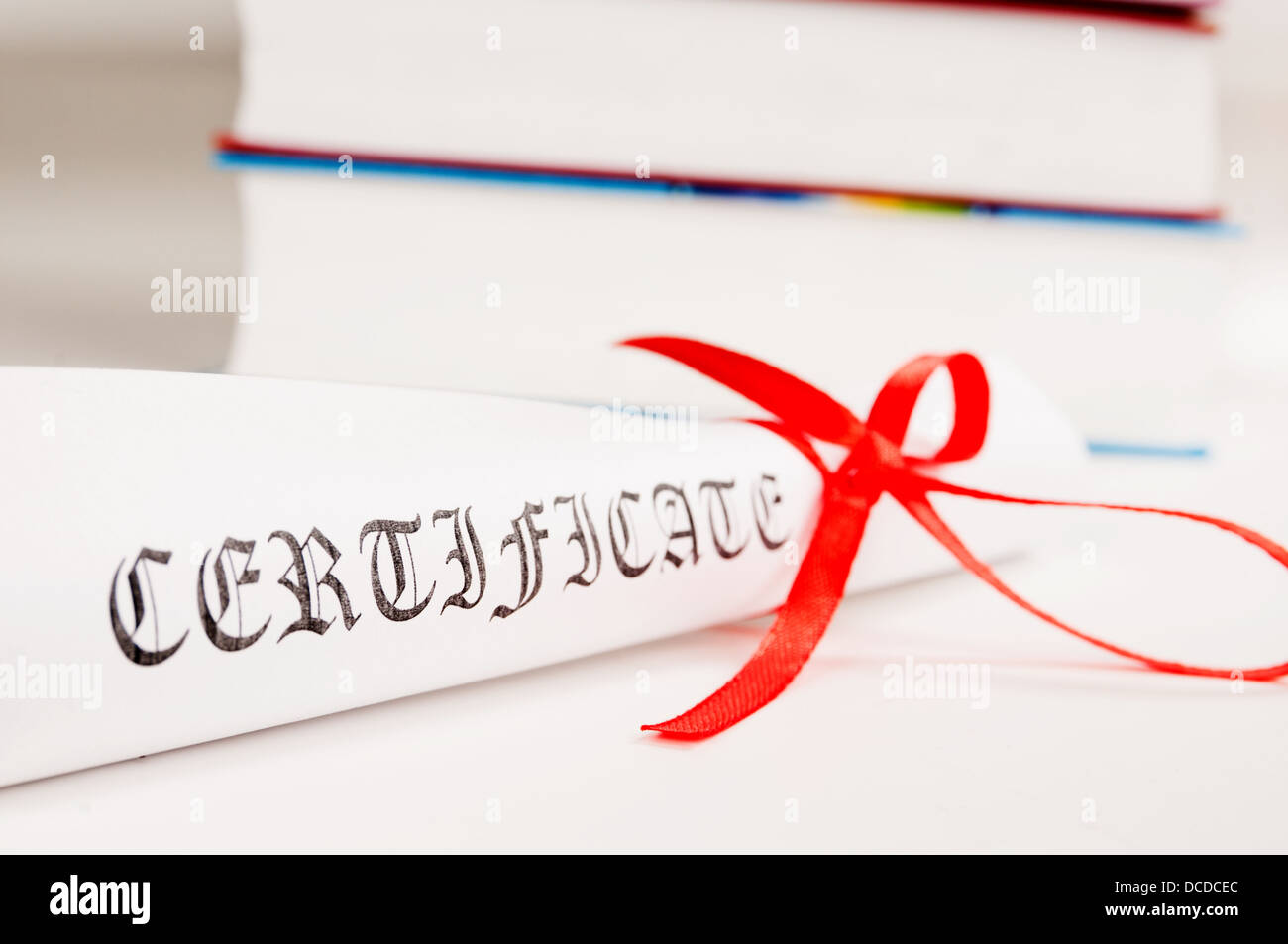 Diploma with red ribbon and books Stock Photo - Alamy