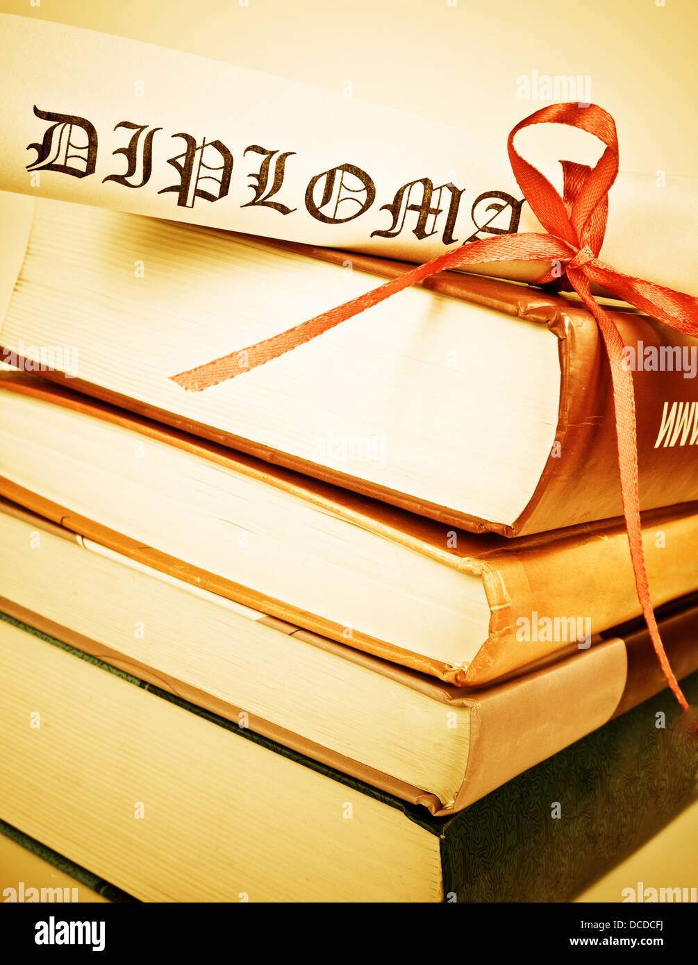 Diploma with red ribbon and books Stock Photo - Alamy