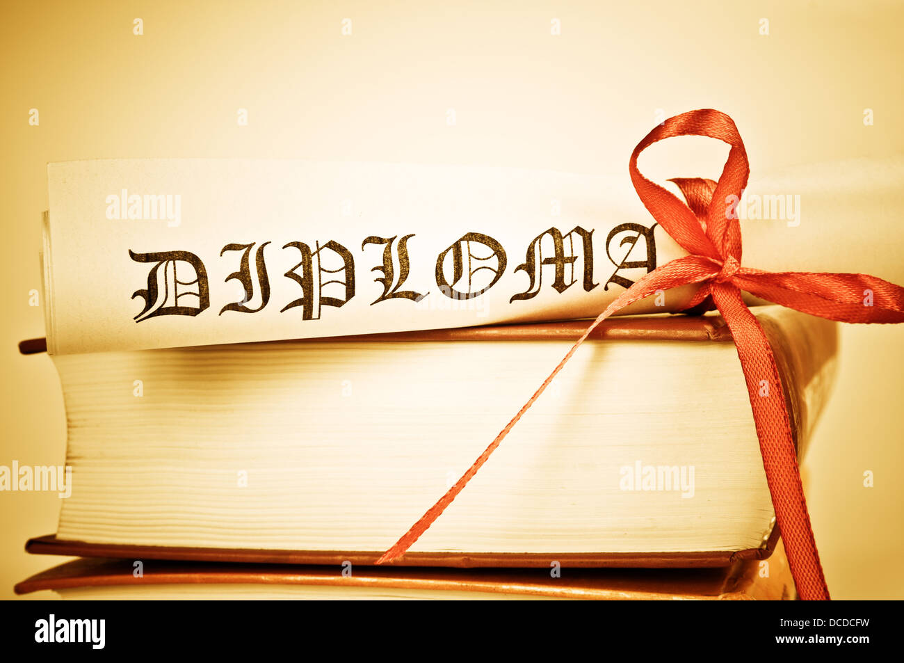Diploma with red ribbon and books Stock Photo - Alamy