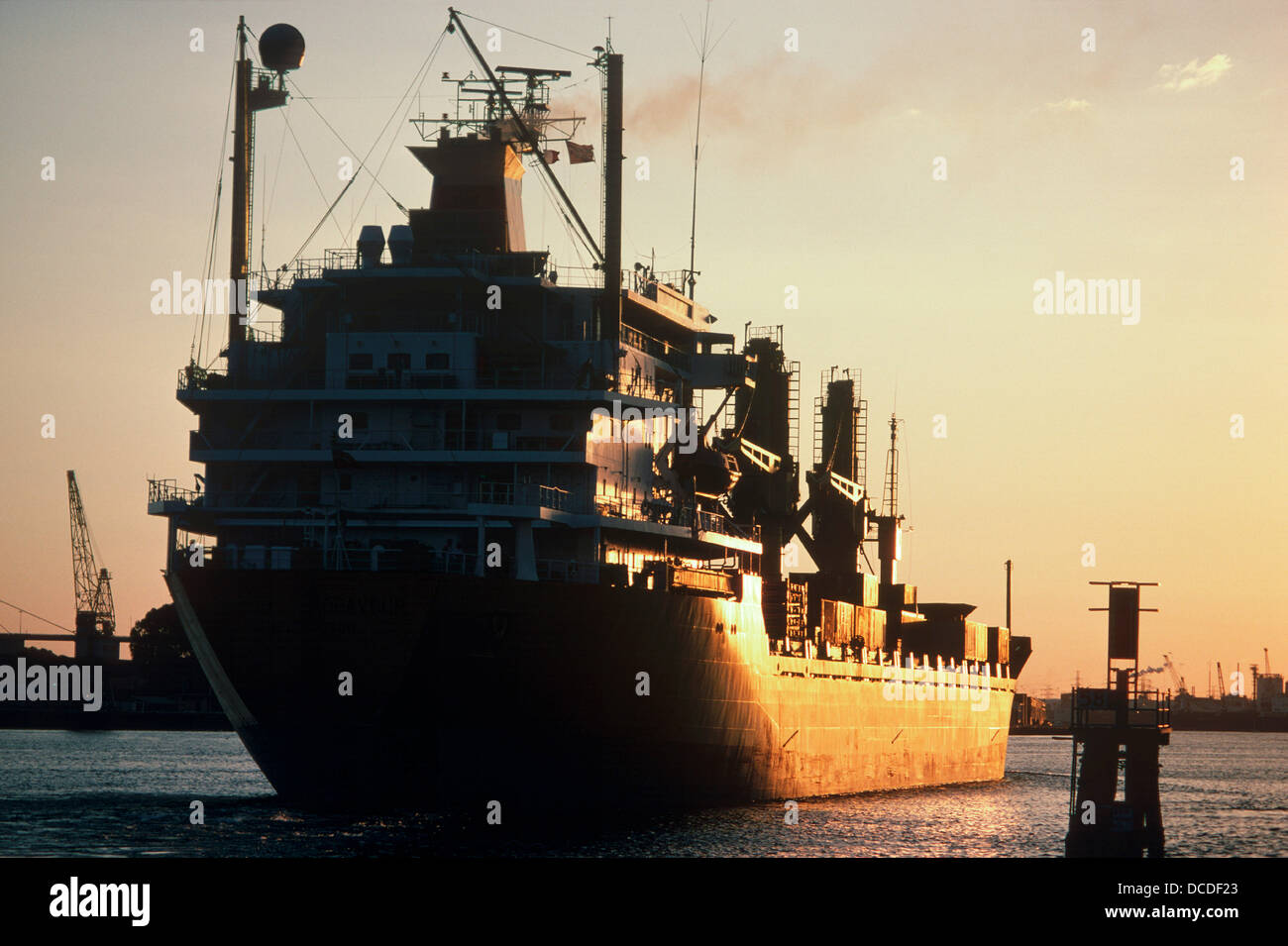 Container ship reflecting gold light from setting sun Stock Photo - Alamy