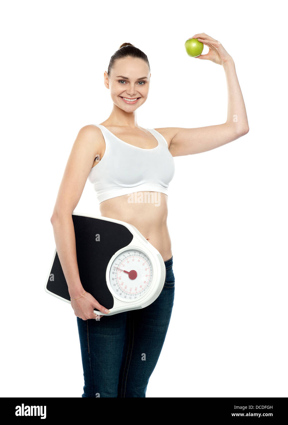 Attractive young female holding weighing machine and green apple ...