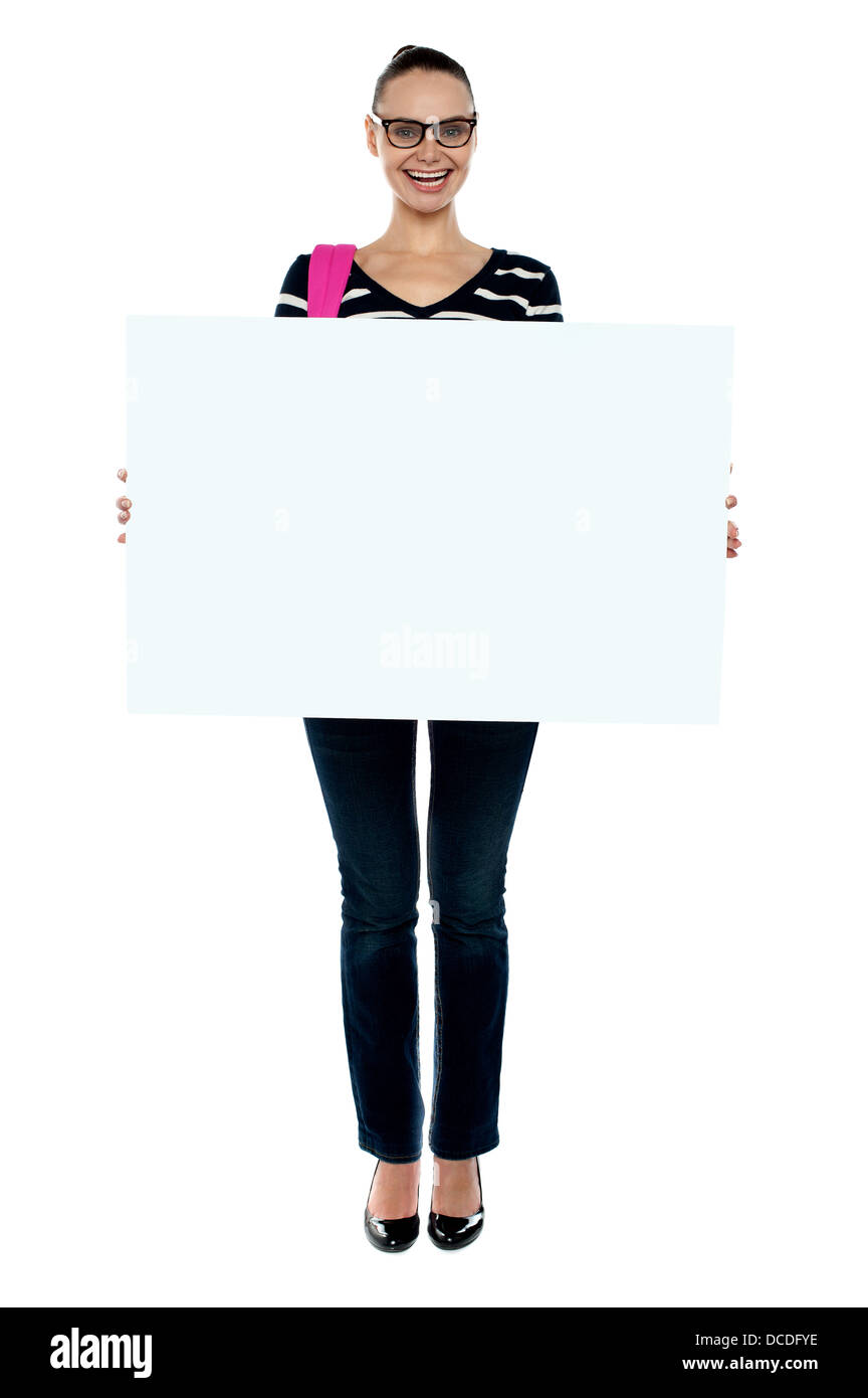 Full length shot of college girl holding white ad board and smiling at ...