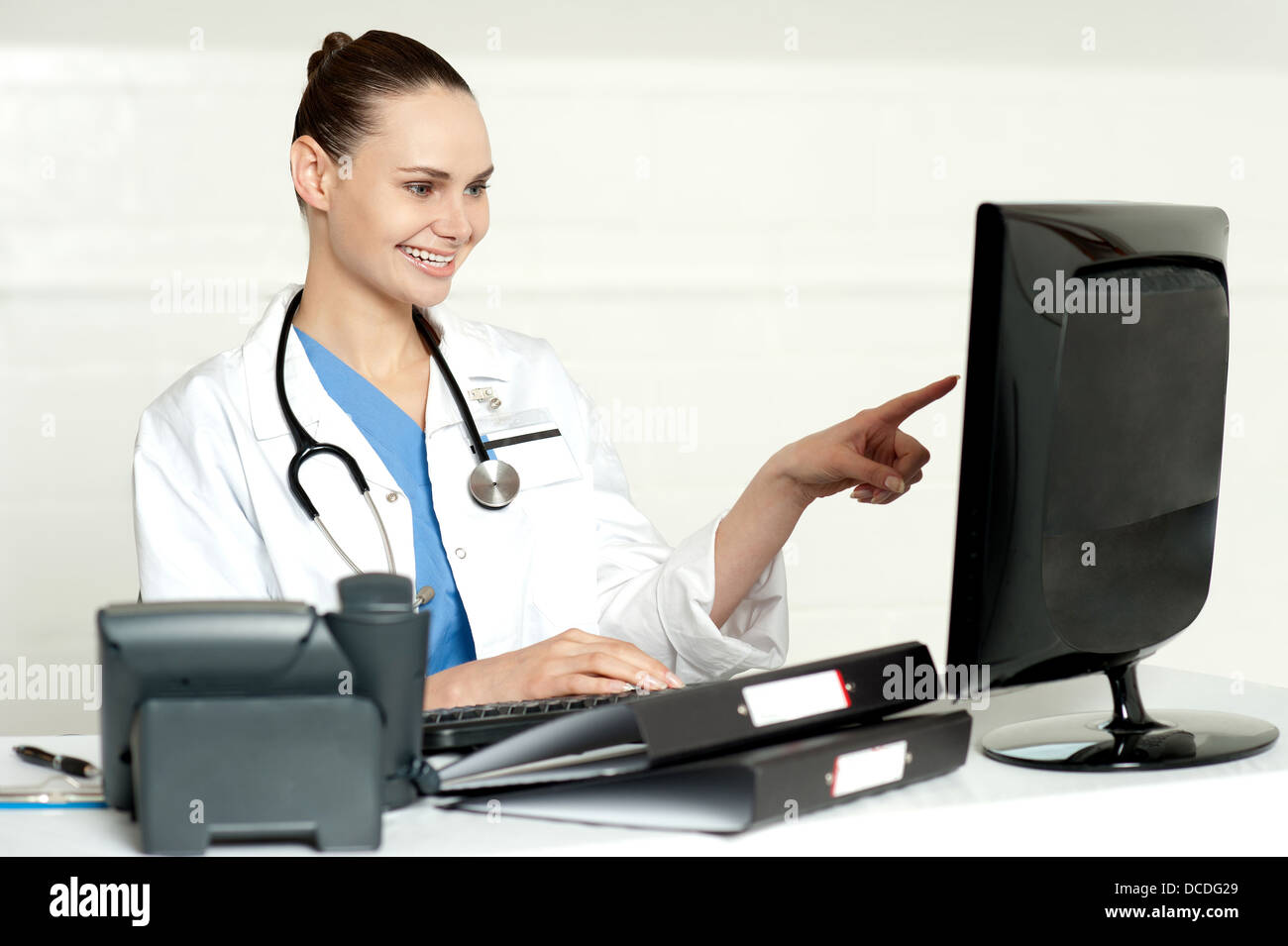 Female medical expert pointing at computer screen sitting in her lab ...