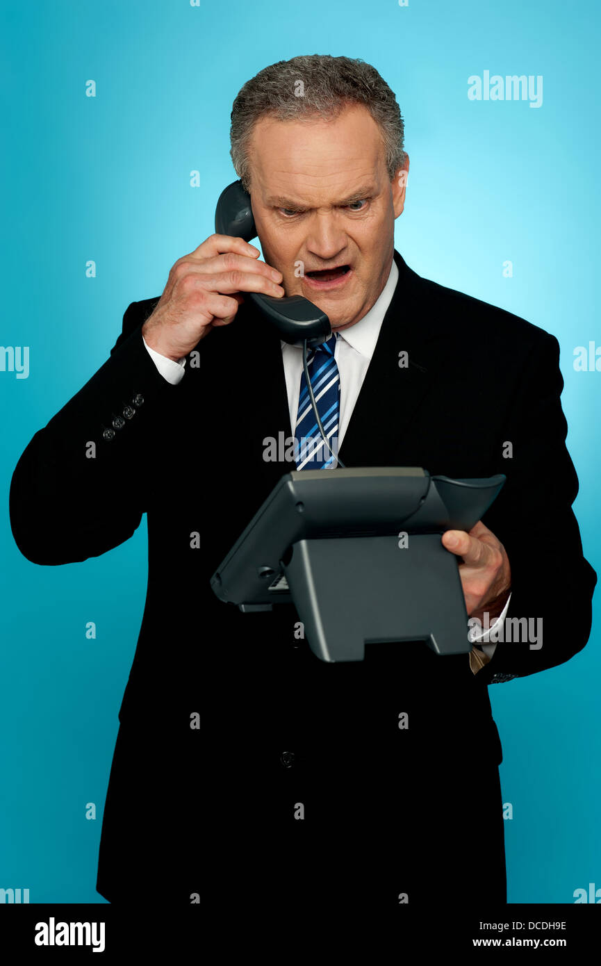 Angry aged corporate man yelling on phone isolated against gradient ...