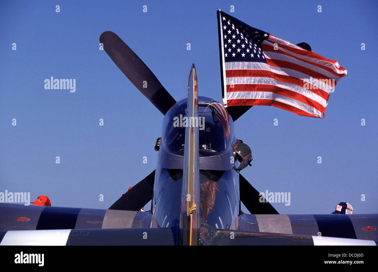 Two heads wearing aviation caps seen just over the striped wings of a ...
