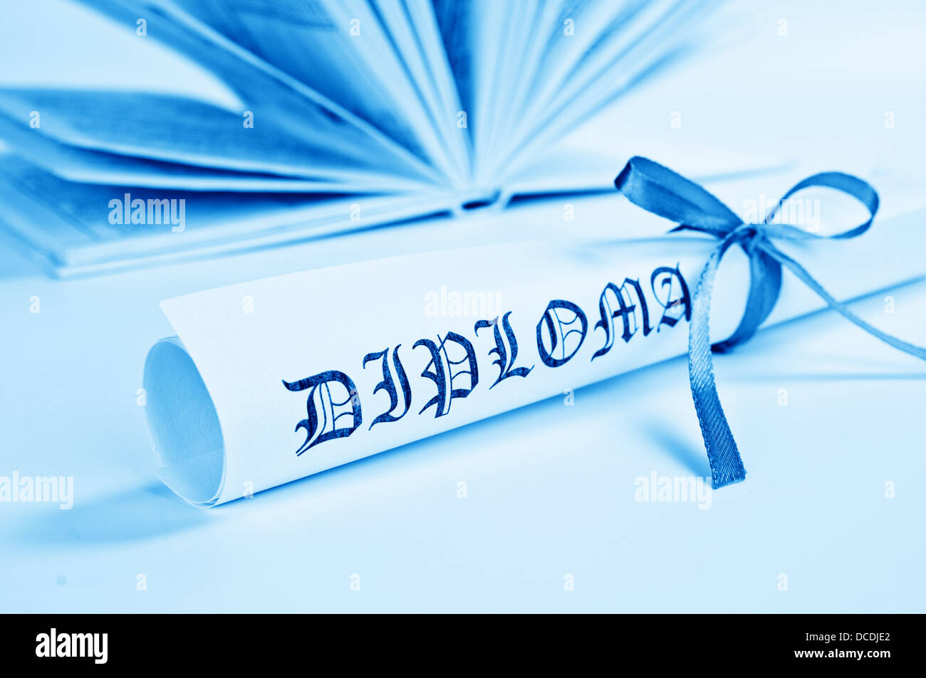 Diploma with blue ribbon and book Stock Photo - Alamy
