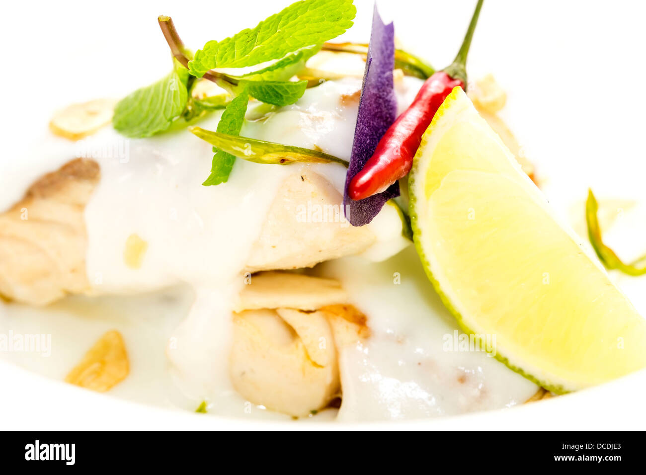 Baked fish in cream sauce with lemon on plate Stock Photo - Alamy