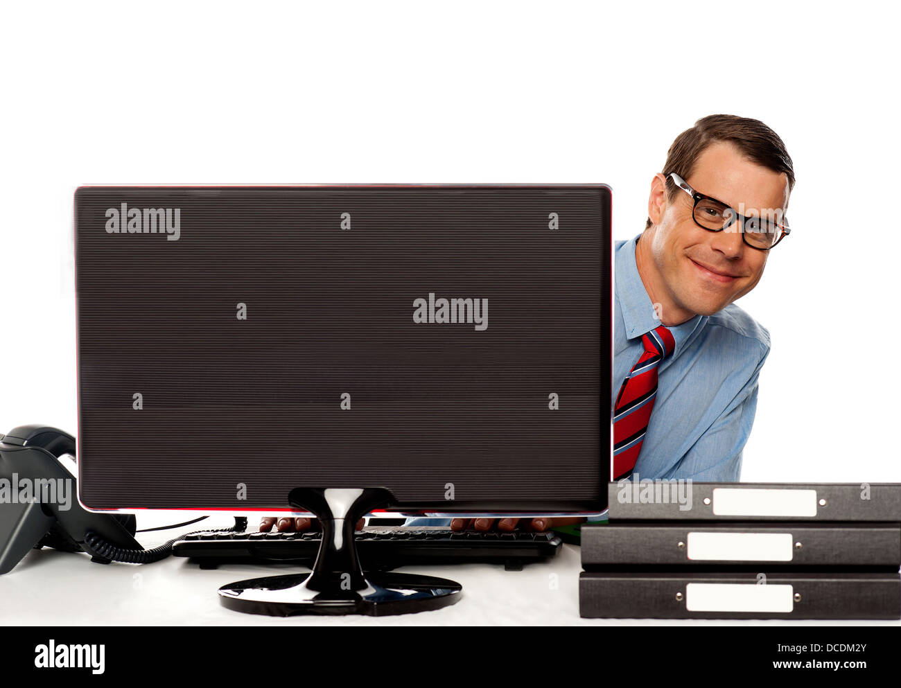 Man peeping from behind computer screen and enjoying at work. Sitting ...