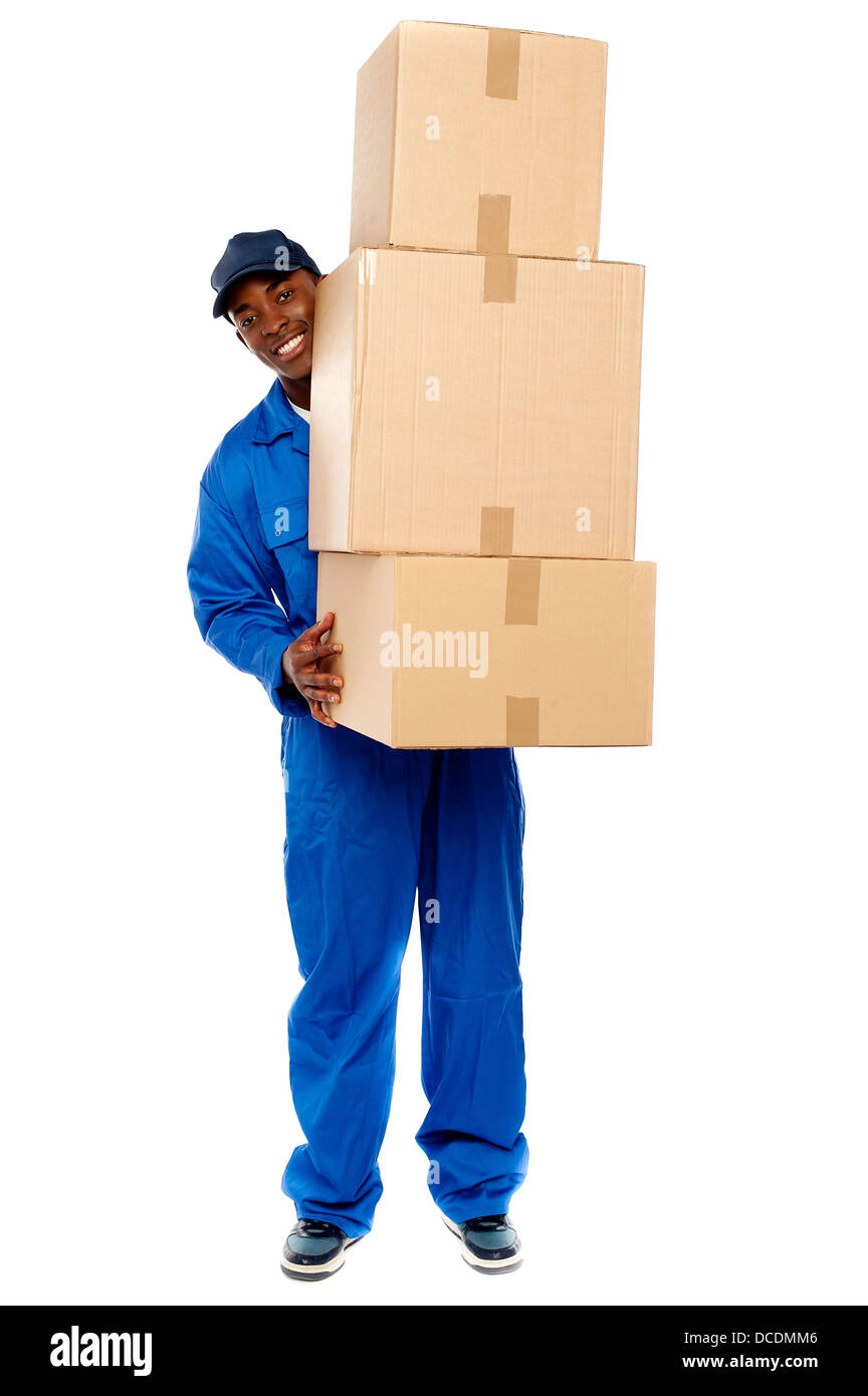 Full length portrait of a delivery boy carrying heavy boxes isolated on ...