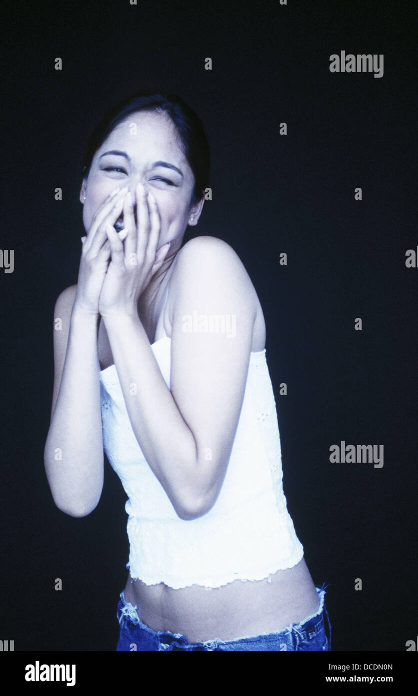 Girl laughing hands over mouth hi-res stock photography and images - Alamy