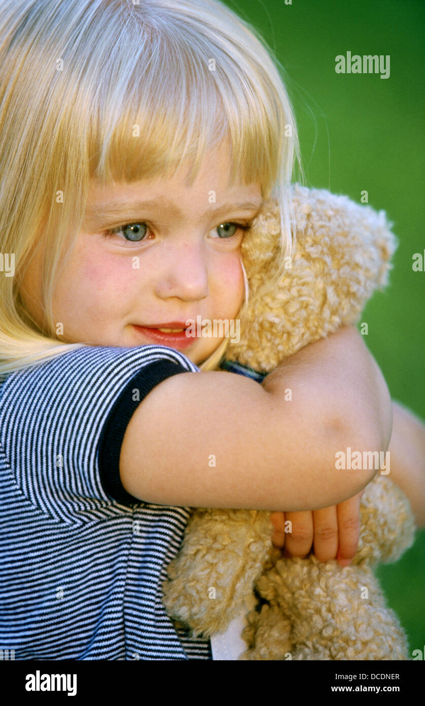 Little girl hugging her teddy bear Stock Photo - Alamy
