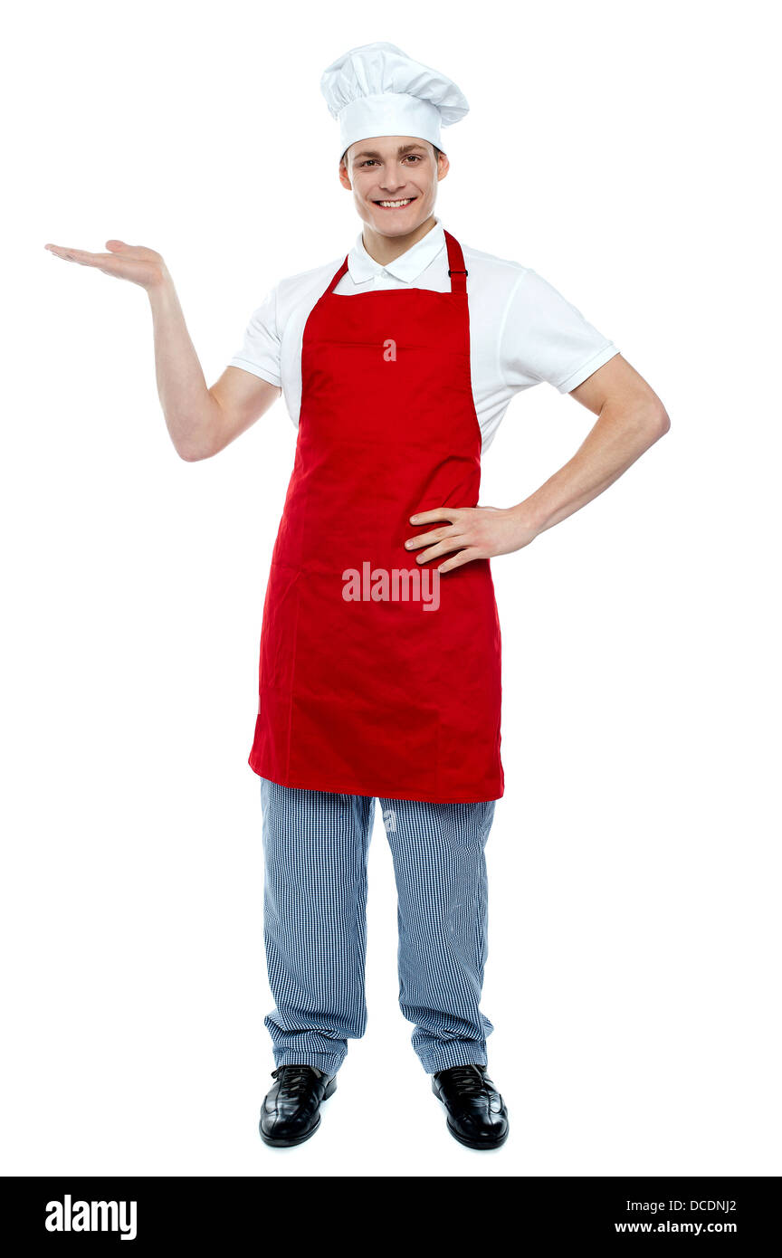 Full length portrait of handsome chef presenting copy space isolated ...