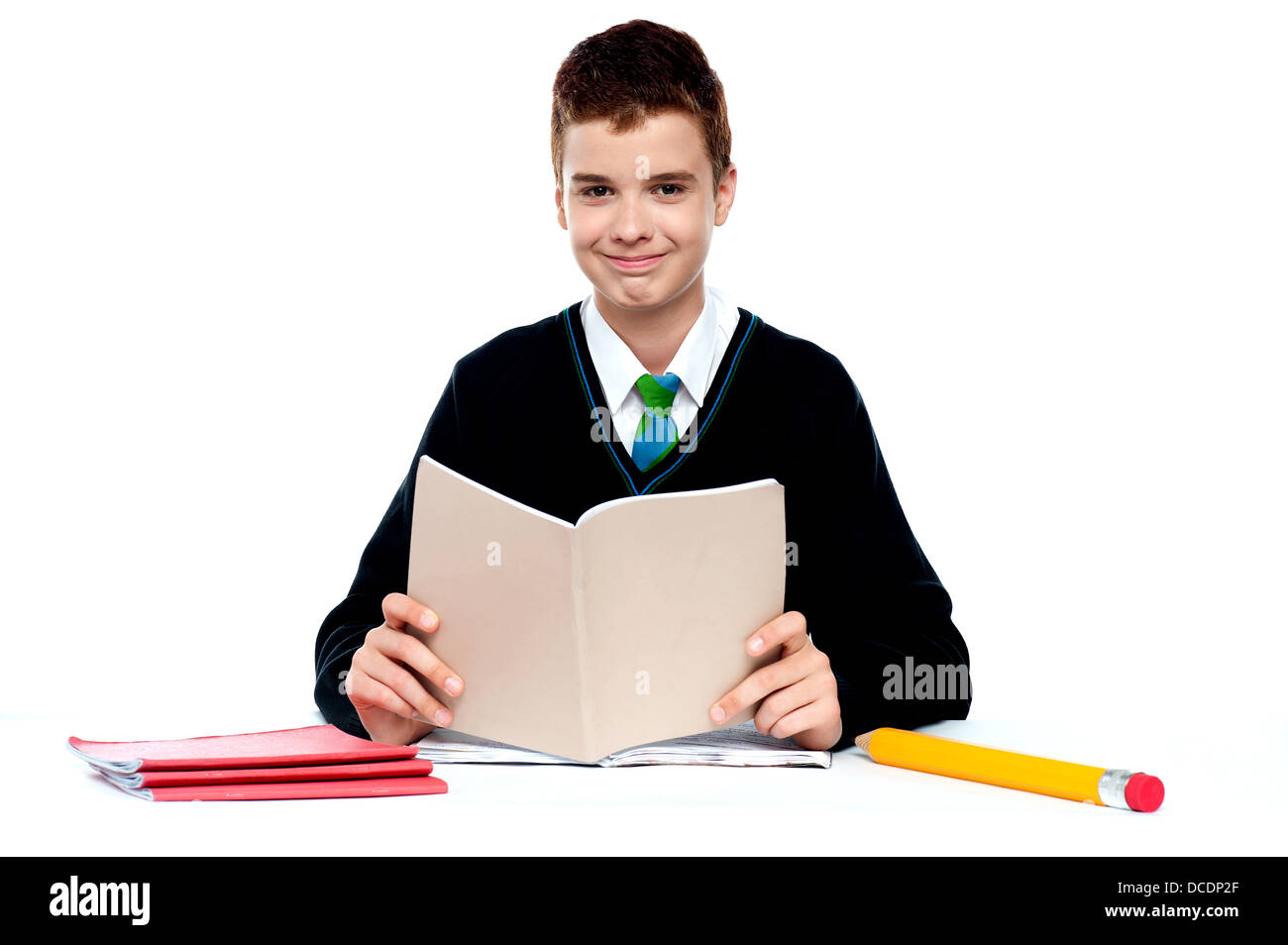 Cute school kid holding notebook and reading looking at camera Stock ...