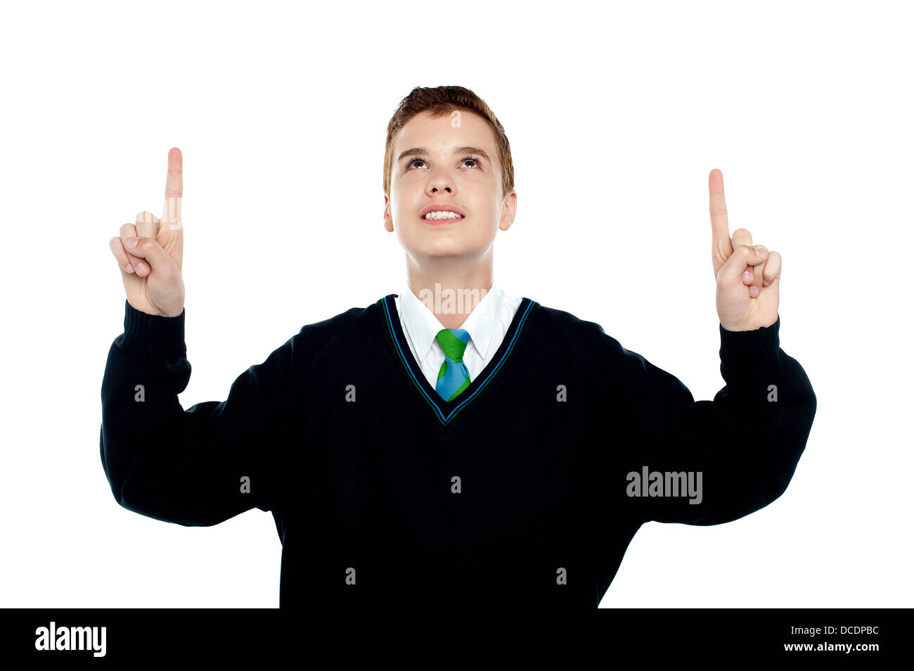 Smiling school kid indicating upwards wearing uniform Stock Photo - Alamy
