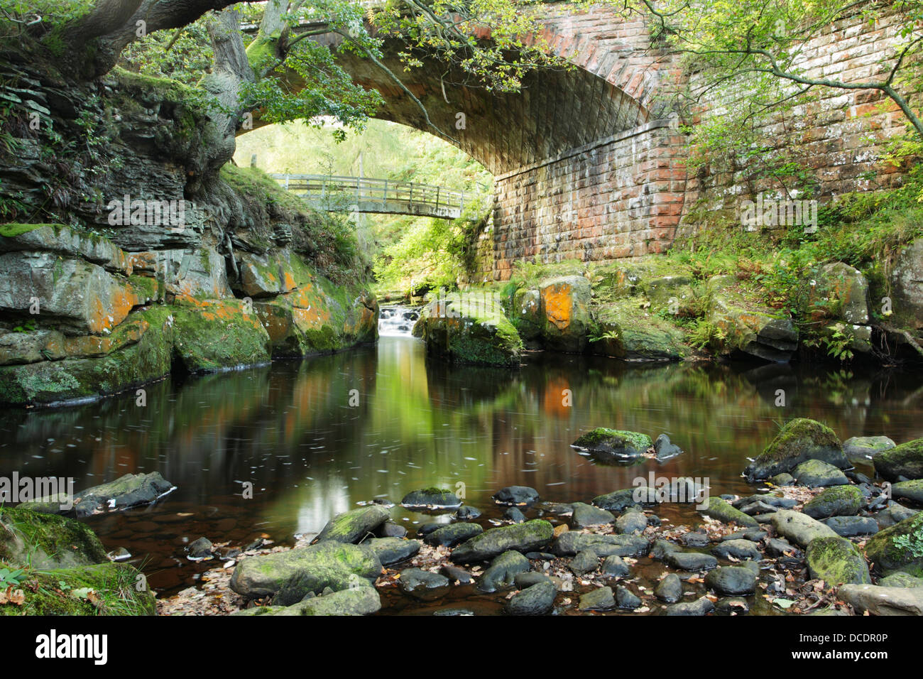 Eller Beck flowing beneath a rail bridge and a pedestrian bridge near ...