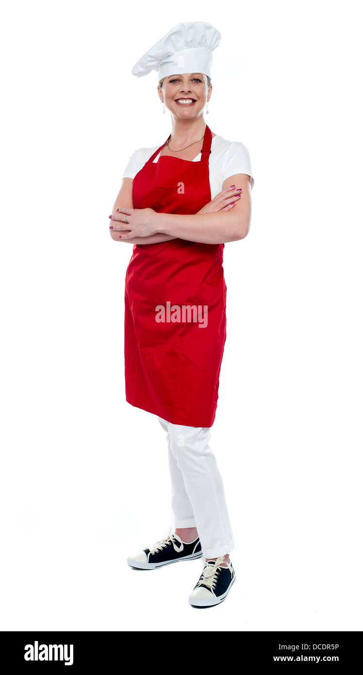 Full length portrait of pretty female cook standing with arms crossed ...