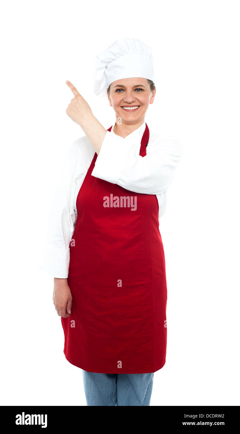 Female chef with red apron pointing copyspace Stock Photo - Alamy