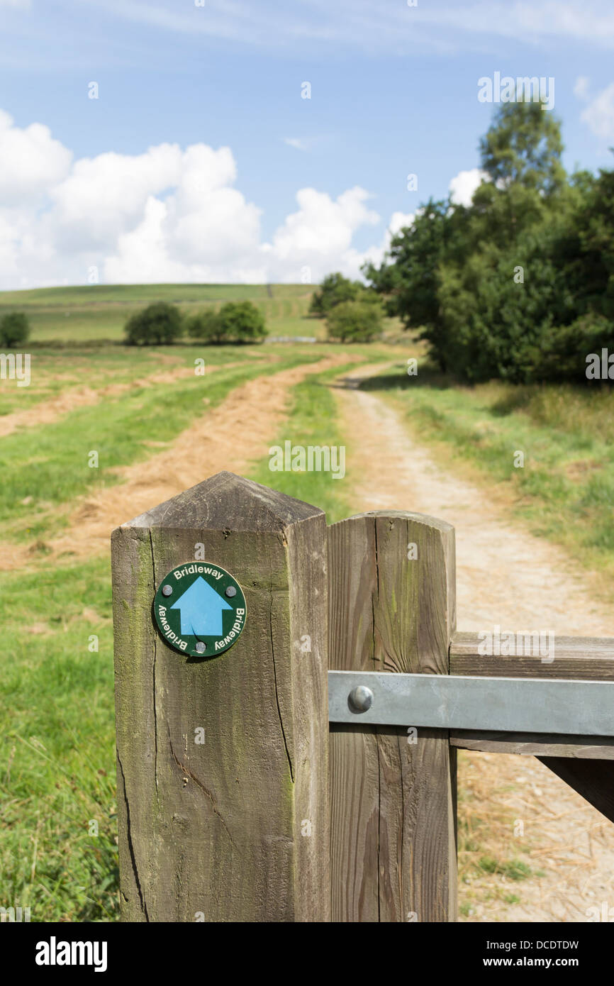 Bridleway indicator on a gatepost pointing up a bridleway between ...