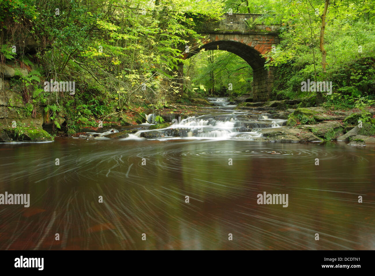 May Beck as it flows under a bridge and over a series of small rock ...