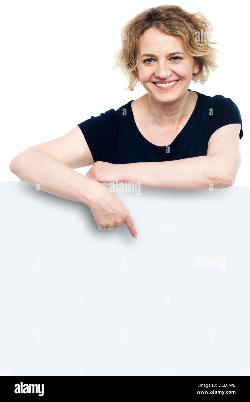 Smiling female pointing at blank whiteboard and smiling at camera Stock ...