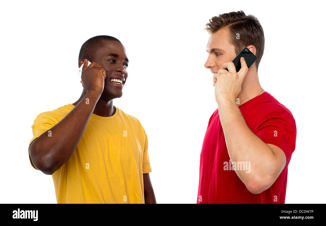 Cool guys communicating via cellphone, looking at each other. All on ...