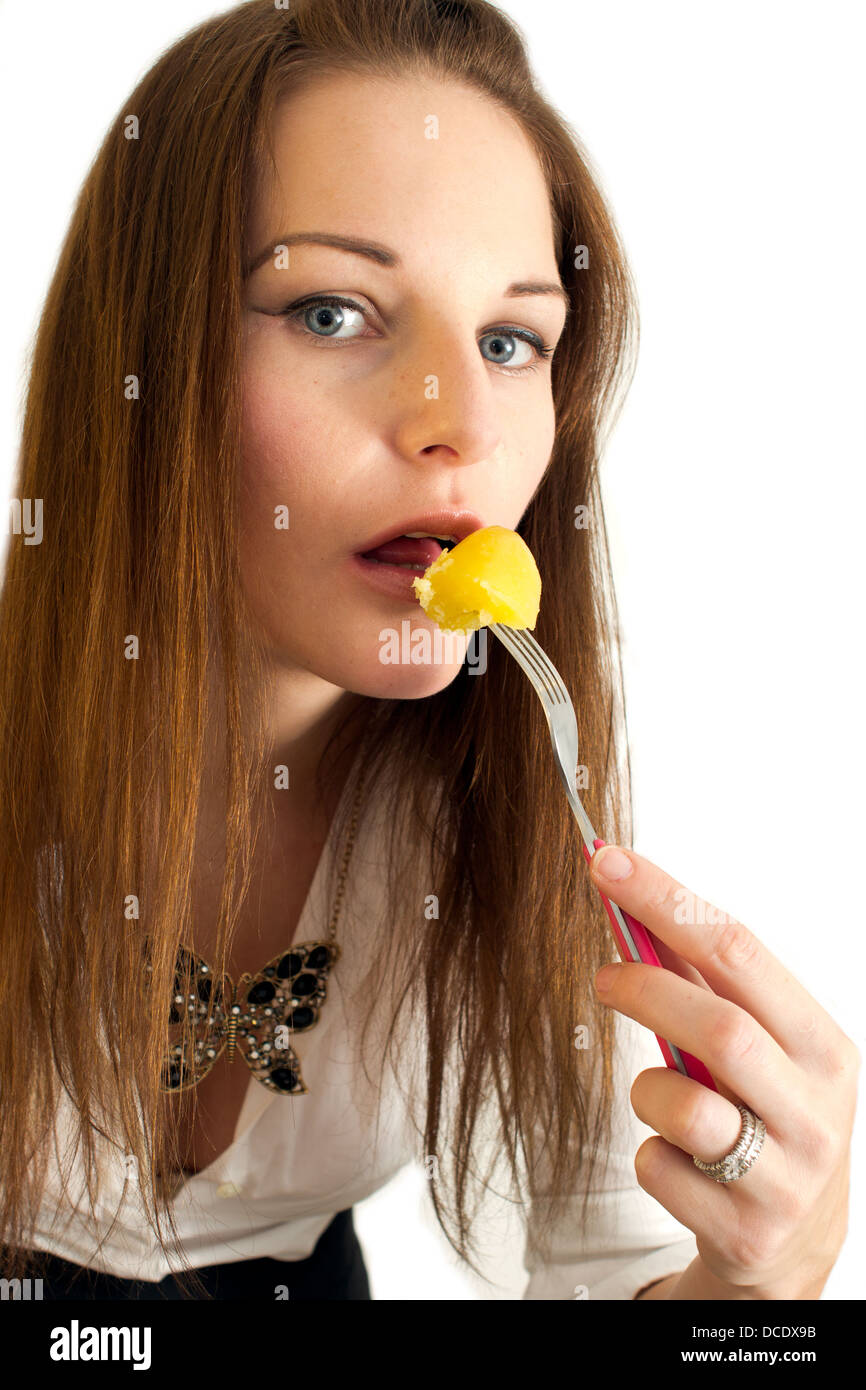 Cute young woman eating a potatoe Stock Photo - Alamy