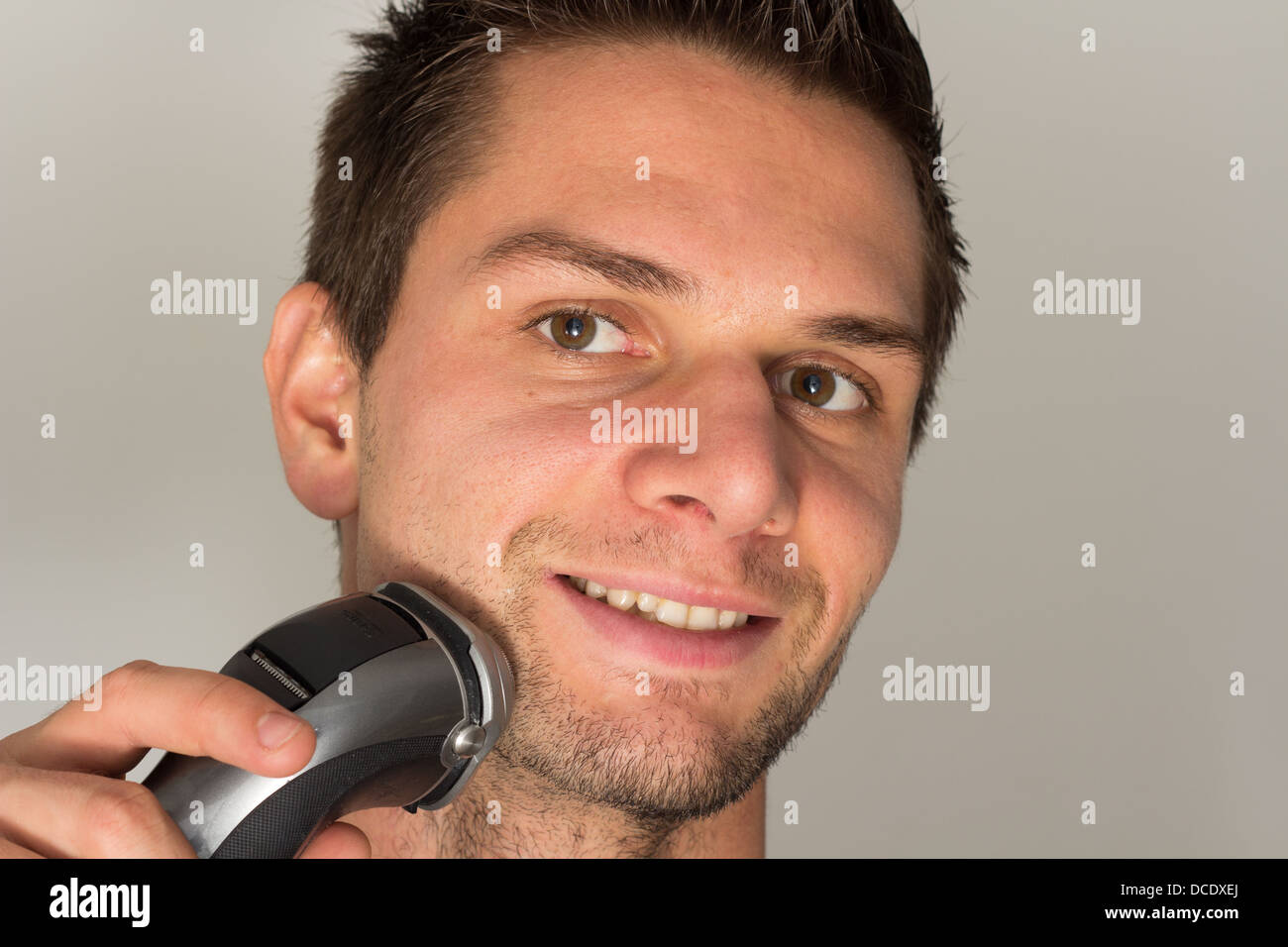 Man shaving face with electric razor Stock Photo - Alamy