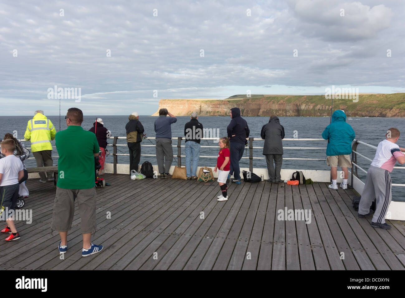 Anglers fishing from the end of Saltburn Pier at high tide on a warm ...