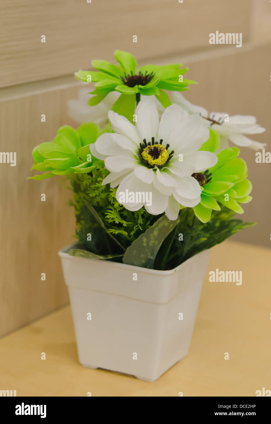 plastic flowers in white vase on table Stock Photo - Alamy