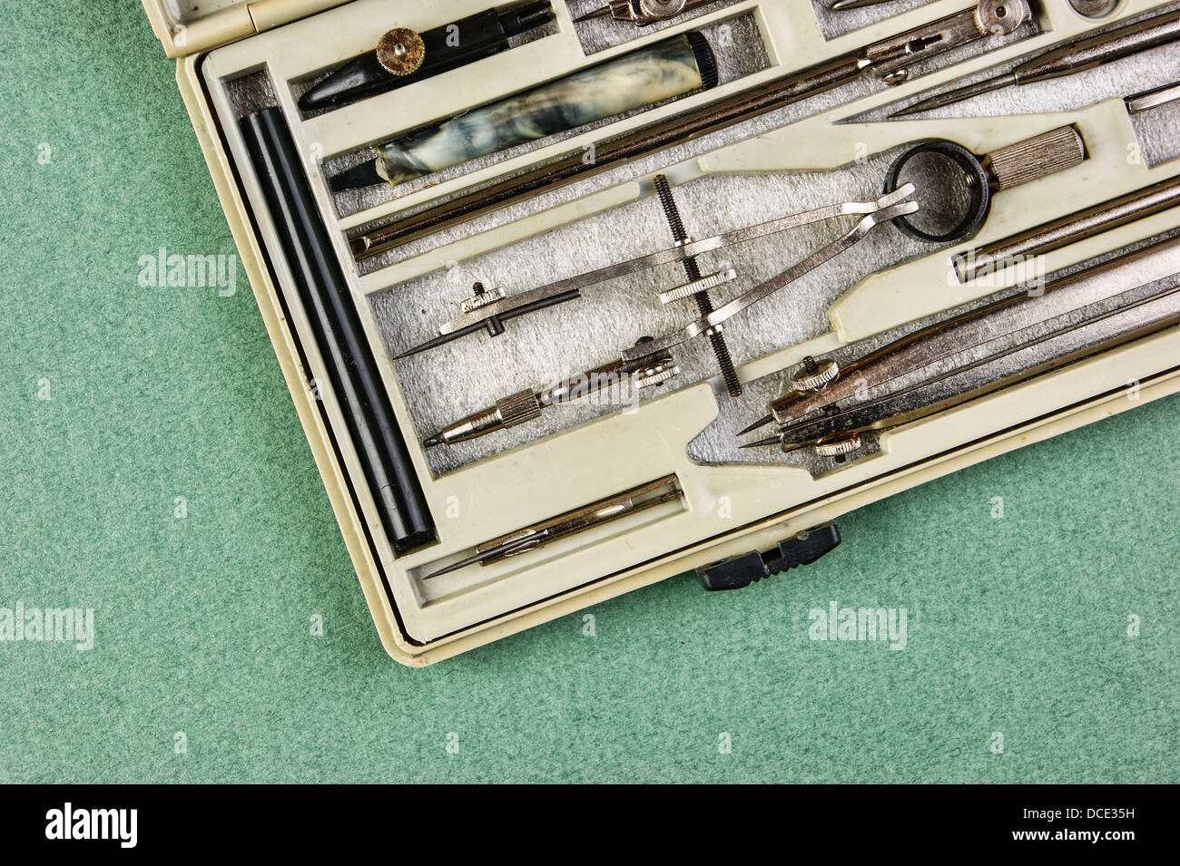 Old drawing tools in a box on a green background Stock Photo - Alamy
