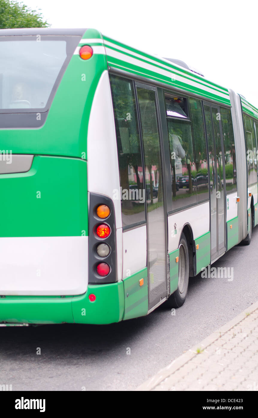 Modern green urban bus leaves from a stop Stock Photo - Alamy