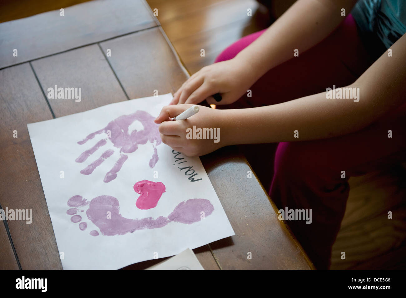 Girl Making Hand And Footprints On Paper Stock Photo - Alamy