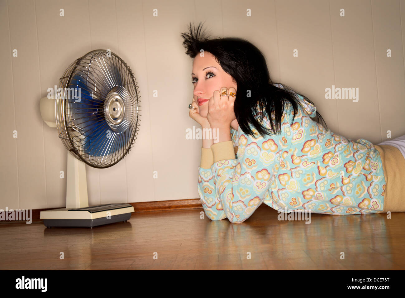 Young Woman Lying In Front Of Fan Stock Photo - Alamy