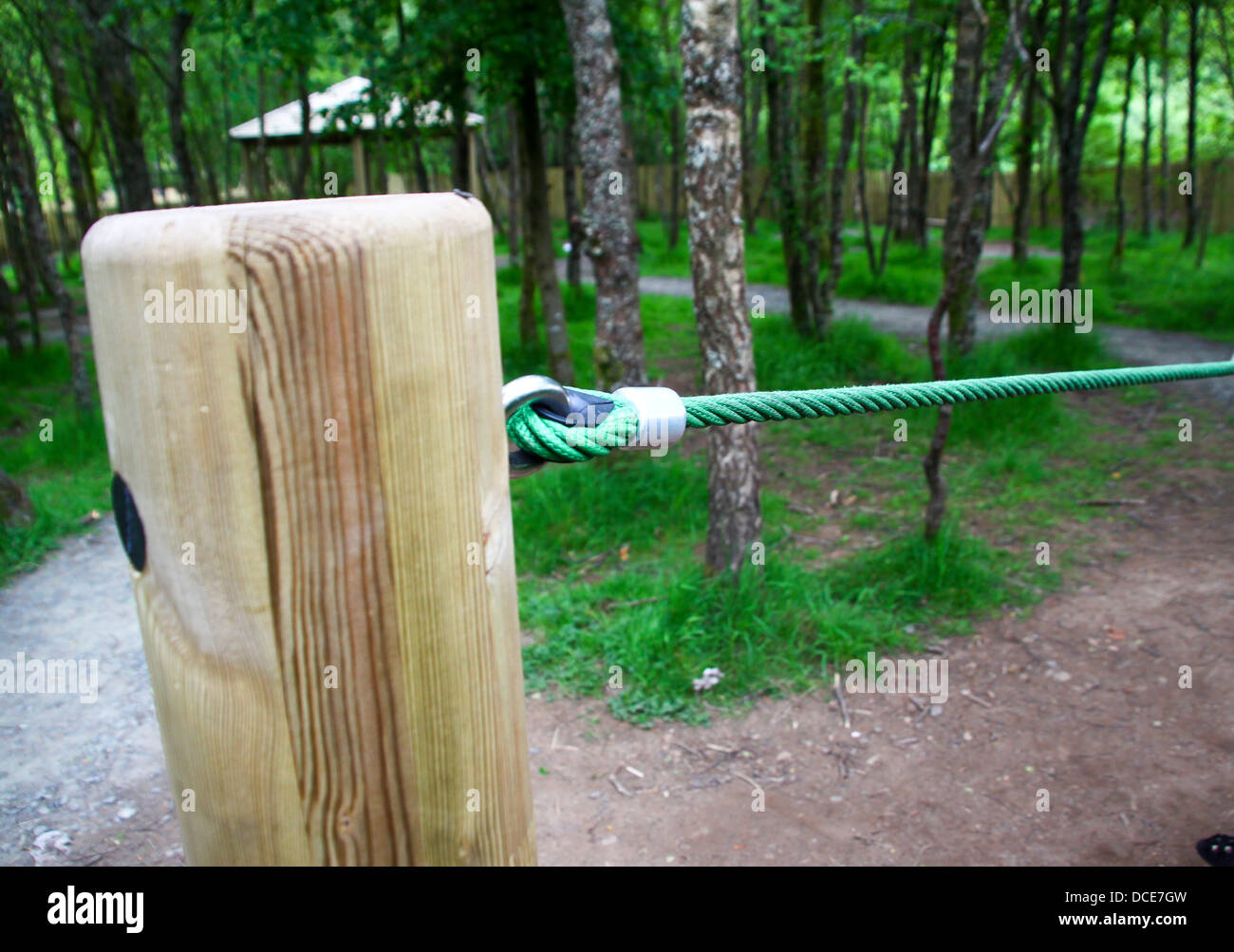 Tensioned rope barrier on wooden post Stock Photo - Alamy