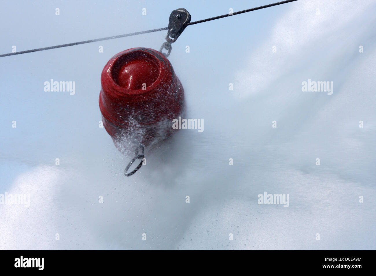 A red barrel on a tether line pushed by fire hoses and water spray in a ...