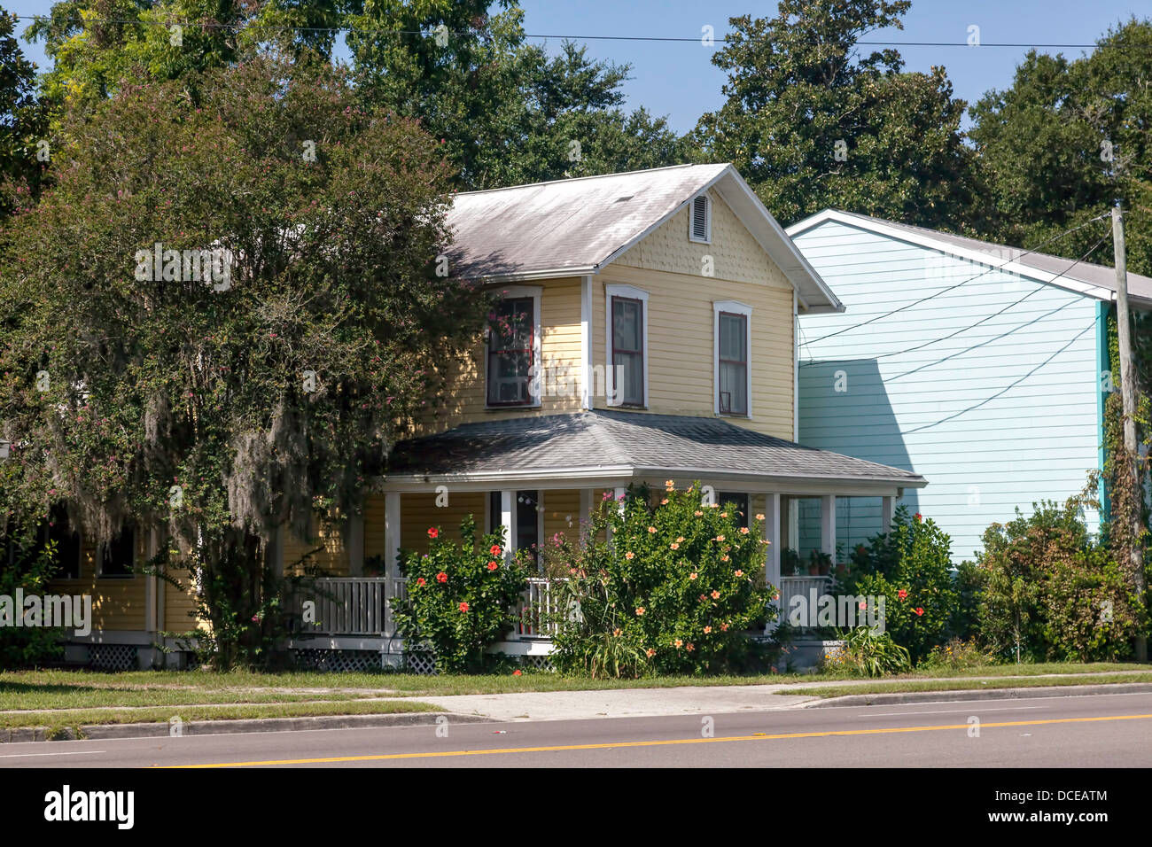 Yellow, 2-story clapboard house with white trim, porch veranda and ...